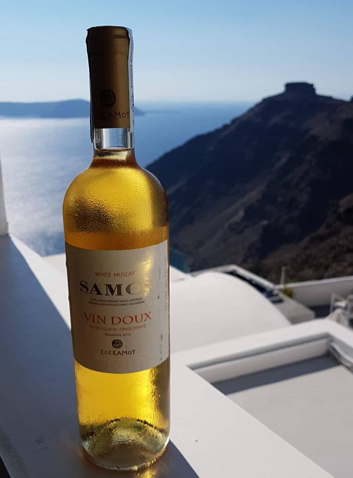 Το κρασί Samos Vin Doux του ΕΟΣ Σάμου με φόντο το ηφαίστειο της Σαντορίνης